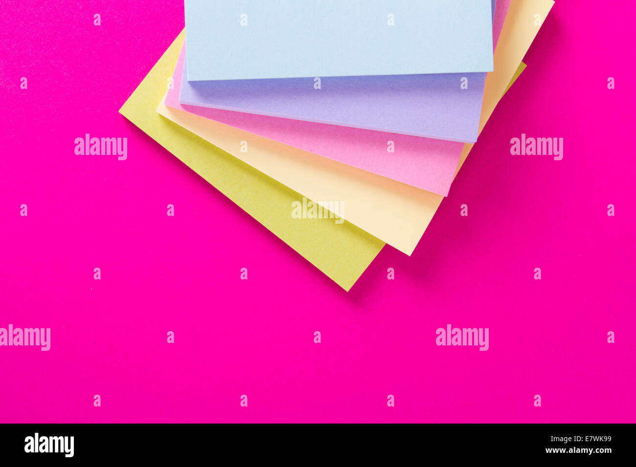 Stack of sticky post it blocks on pink background Stock Photo - Alamy