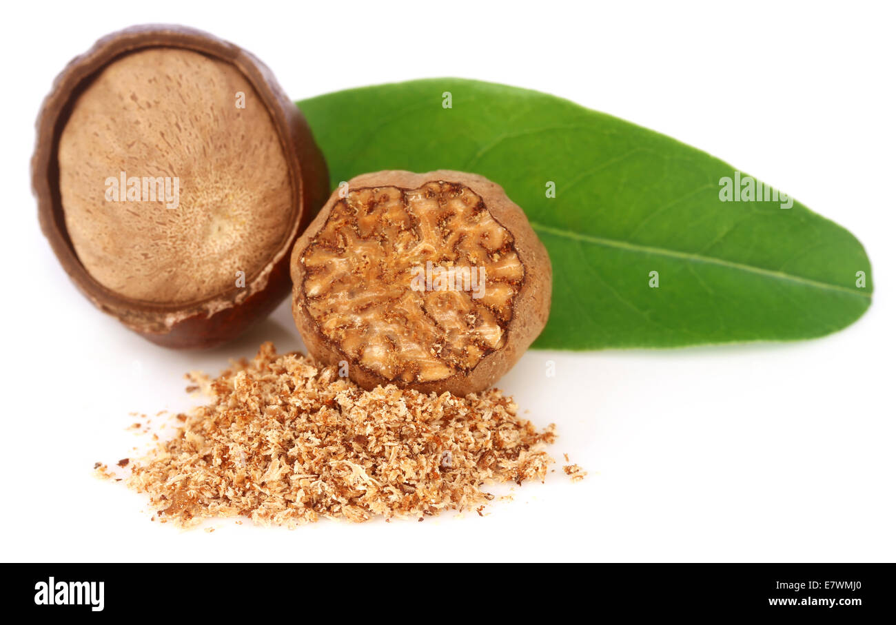 Nutmeg with green leaves over white background Stock Photo - Alamy