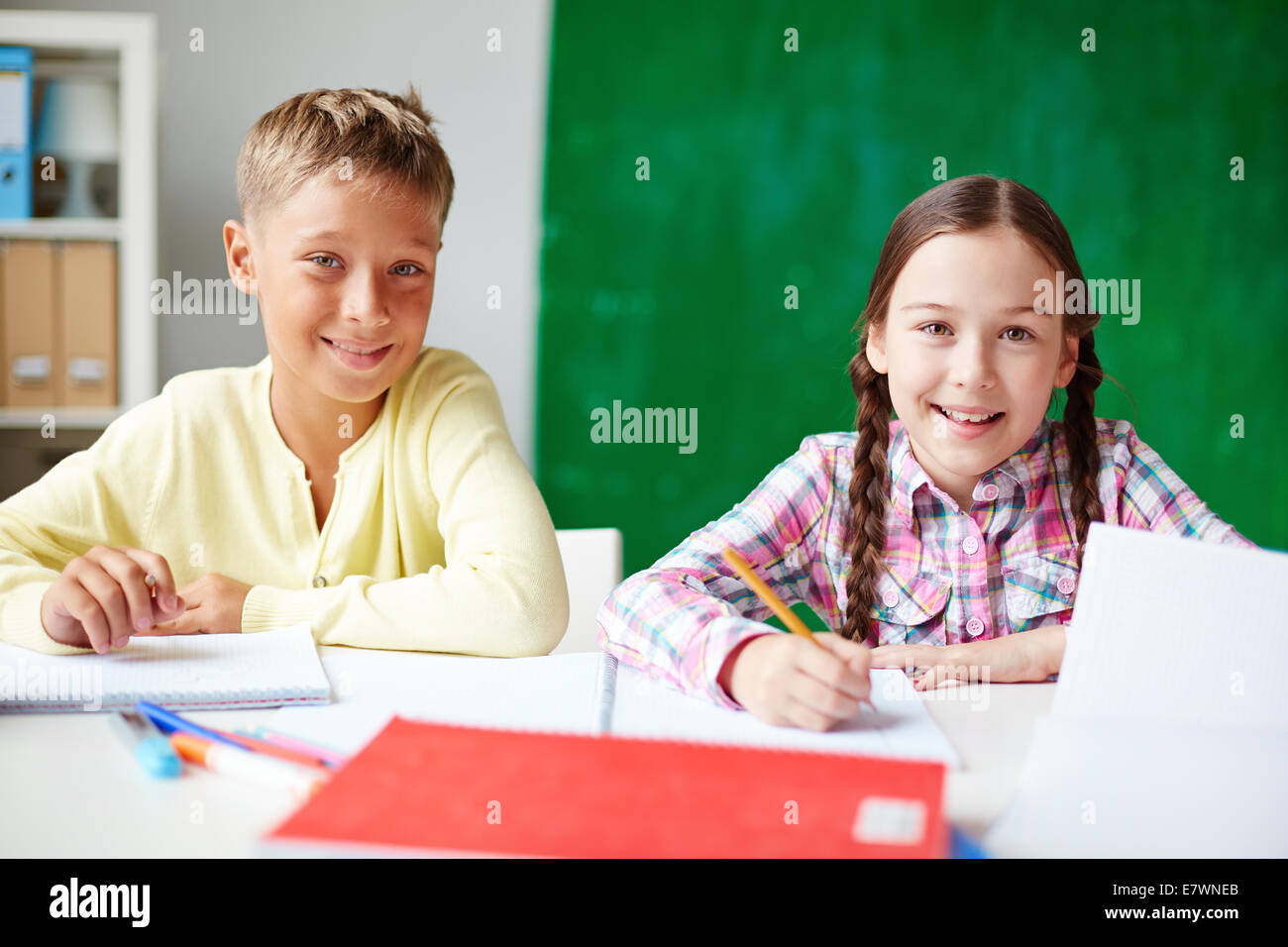 Portrait of happy classmates looking at camera at lesson of drawing ...