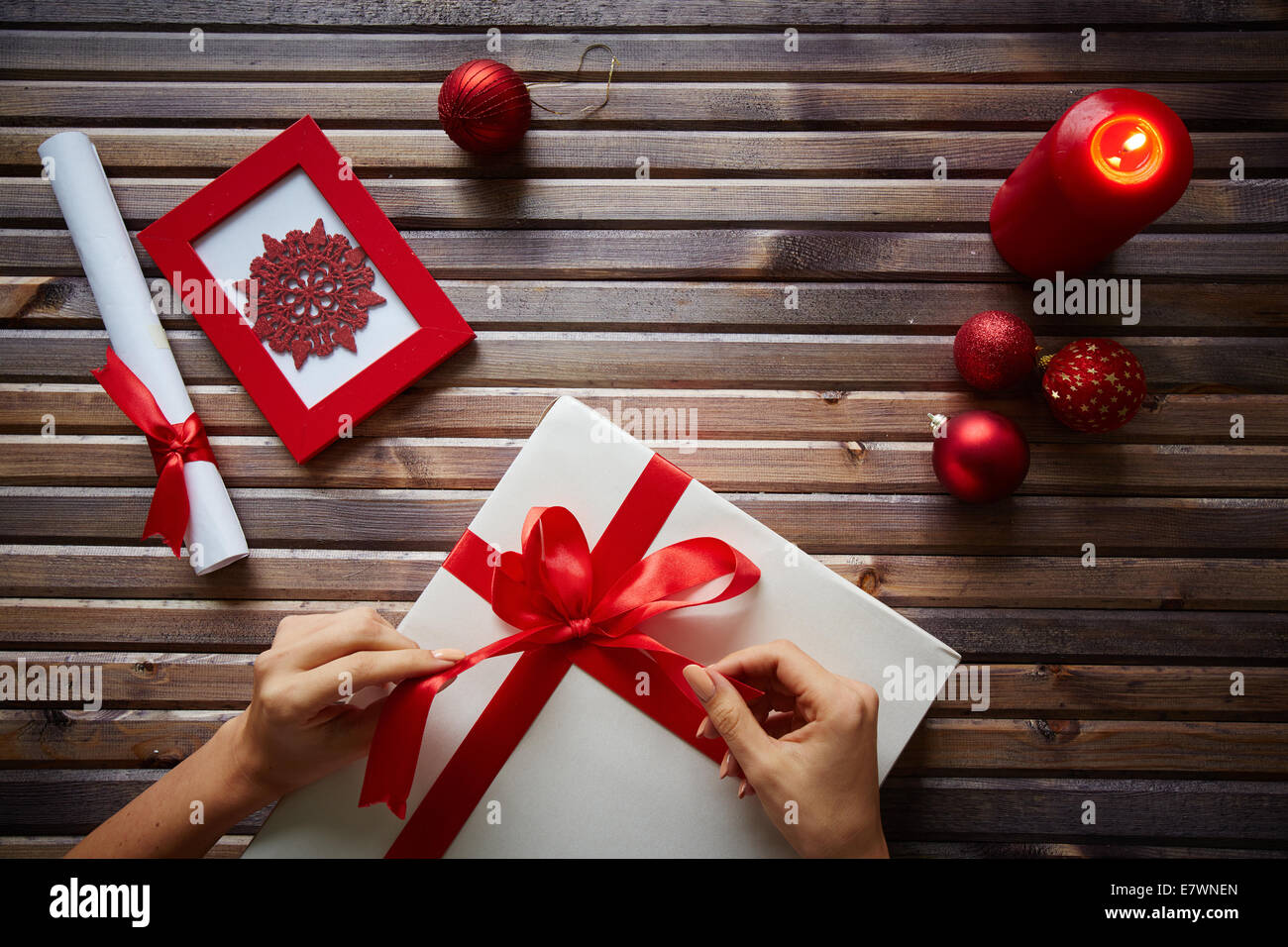 Female hands tying knot on giftbox and different Christmas symbols ...