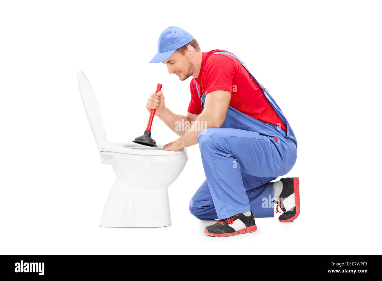 Male plumber working on a toilet with a plunger isolated on white ...