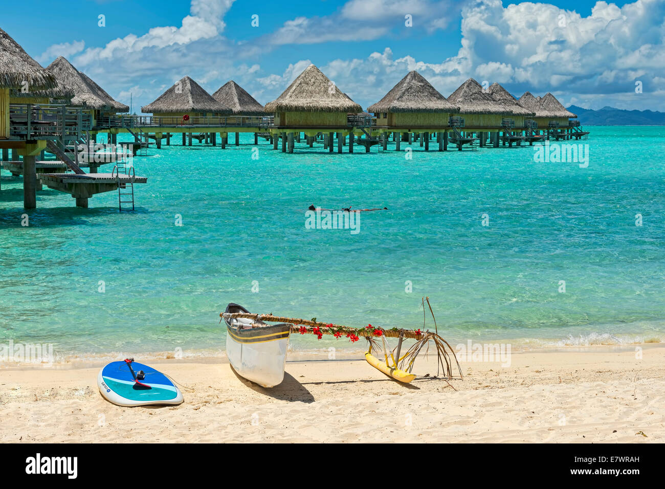 Decorated outrigger boat in front of overwater bungalows, Bora Bora ...