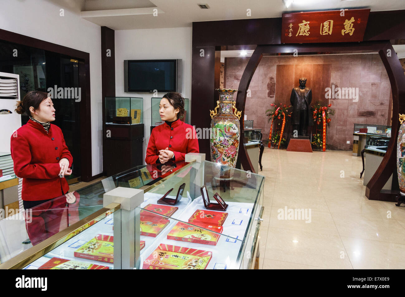 Uniformed vendor women at a luxurious Mao Zedong memorabilia shop with ...