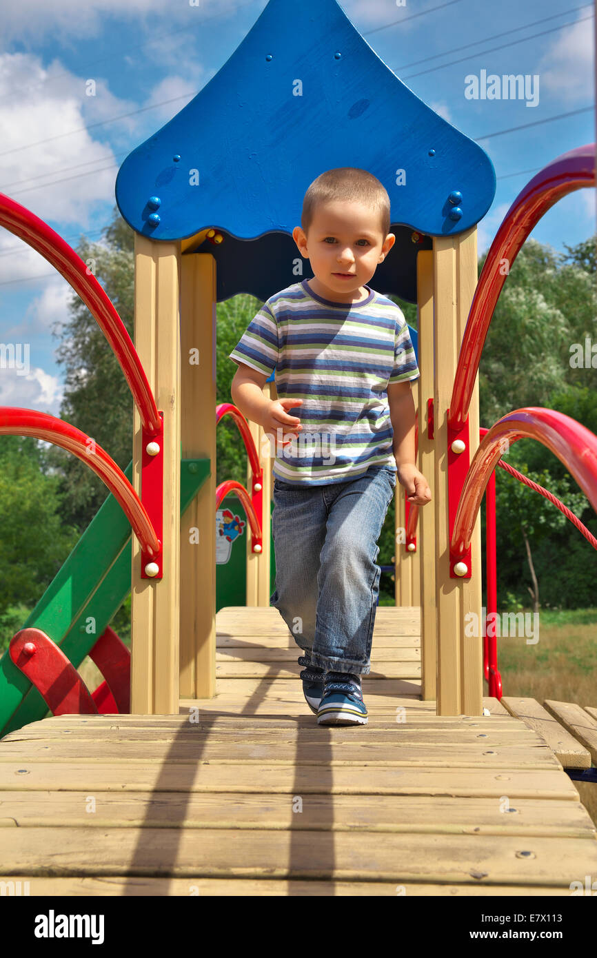 Little boy in jeans and t-shirt playing on the playground Stock Photo ...