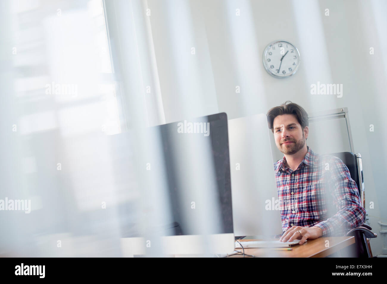 View through an office partition of a man seated at a desk Stock Photo ...