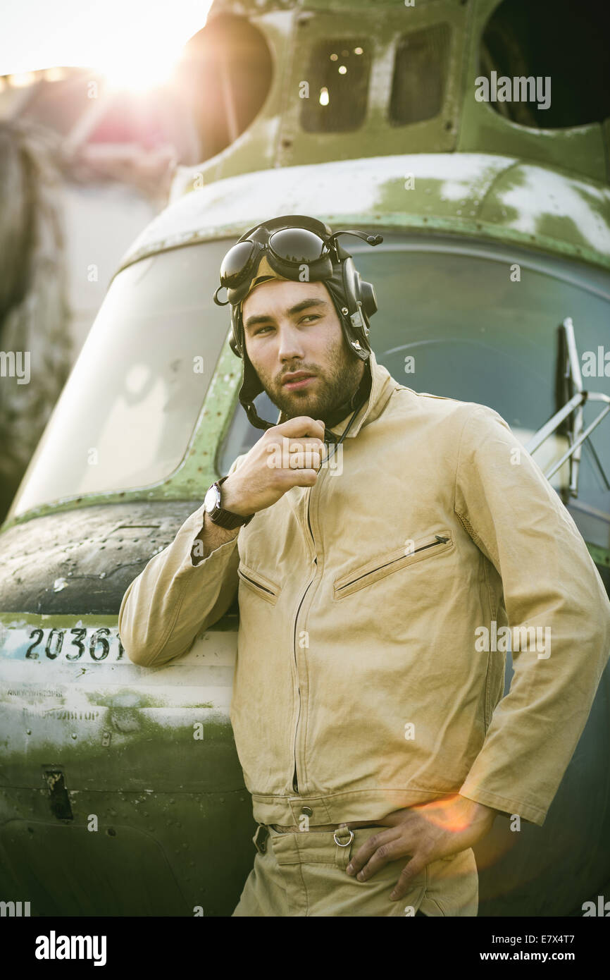 Young serious pilot posing near the helicopter Stock Photo - Alamy