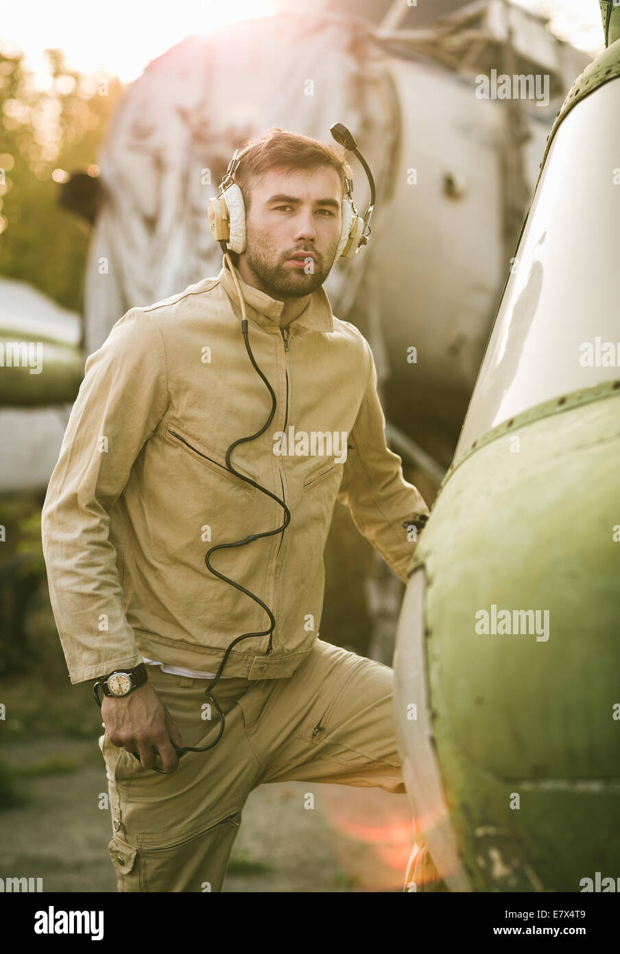 Young serious pilot posing near the helicopter Stock Photo - Alamy