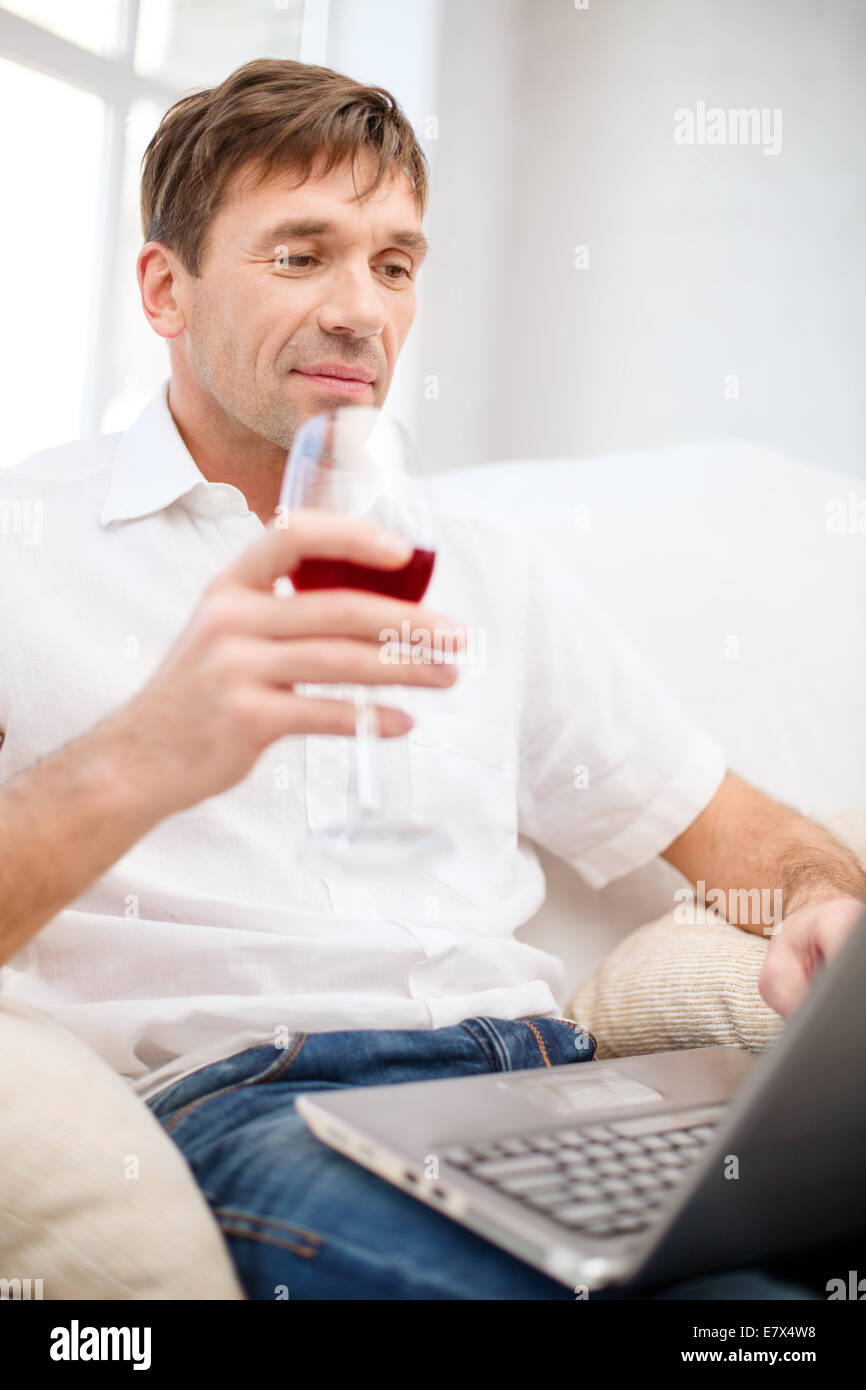 man with laptop computer and glass of red wine Stock Photo - Alamy