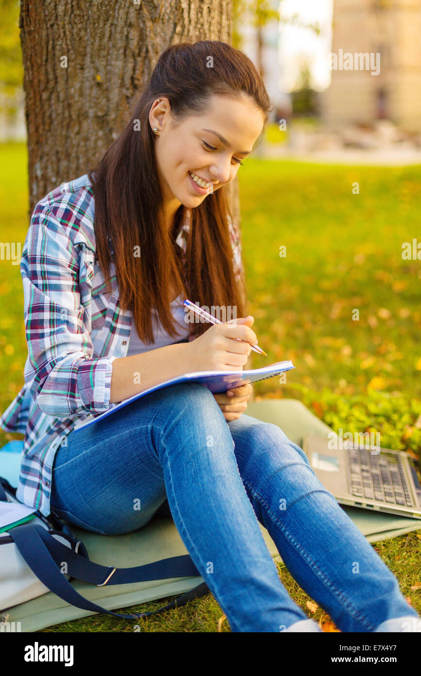 smiling teenager writing in notebook Stock Photo - Alamy