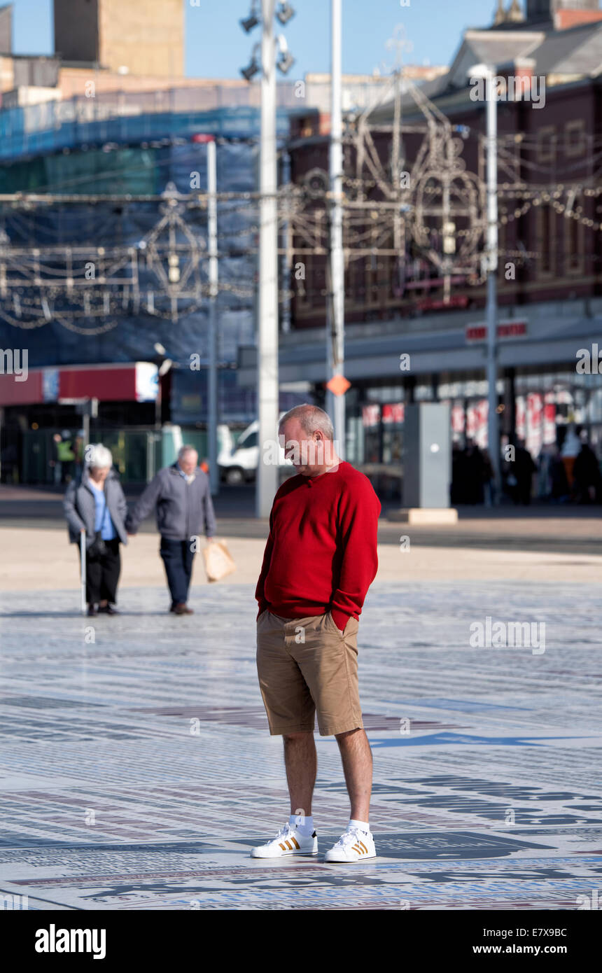 Man in shorts reading text from the "Comedy Carpet" on Blackpool ...
