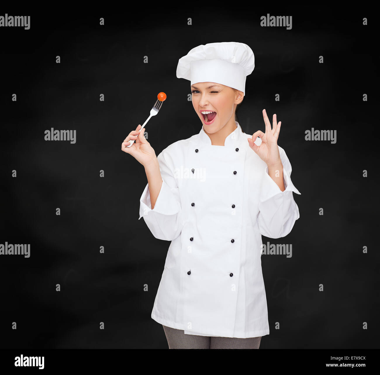 smiling female chef with fork and tomato Stock Photo - Alamy