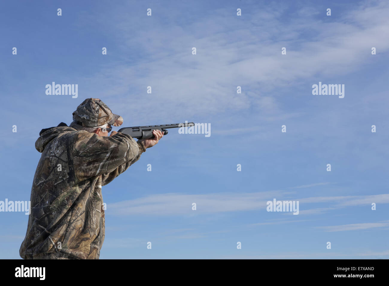 Man in field hunting aiming up into the sky with shot gun Stock Photo ...
