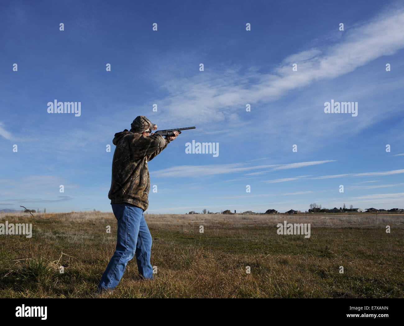 Man in field hunting aiming up into the sky with shot gun Stock Photo ...