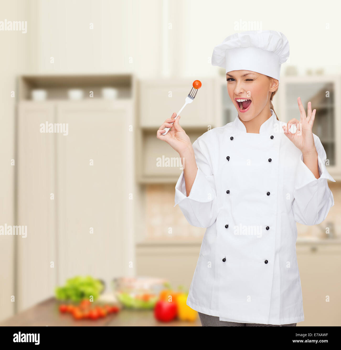 smiling female chef with fork and tomato Stock Photo - Alamy