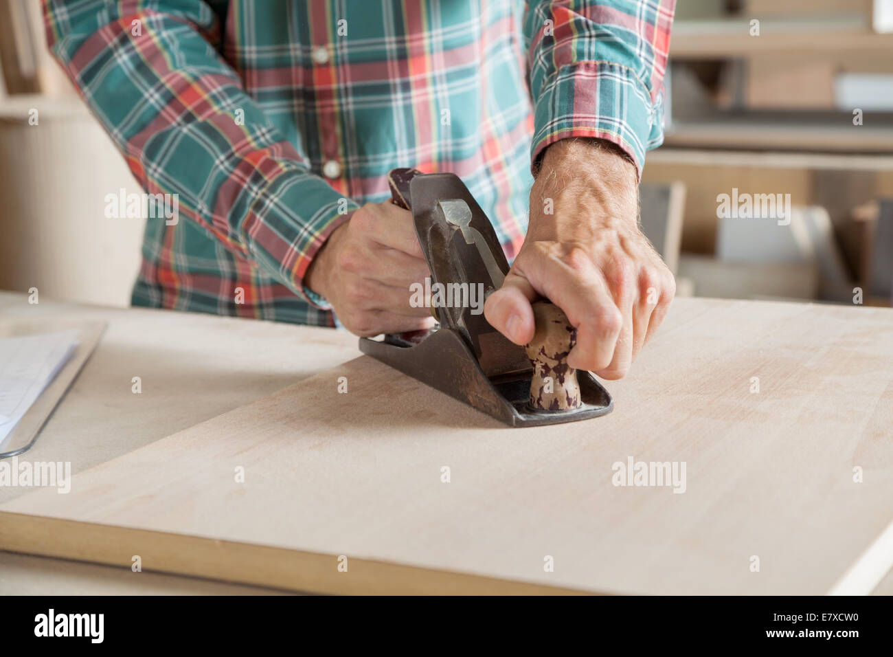 Carpenter Using Planer On Wood In Workshop Stock Photo - Alamy