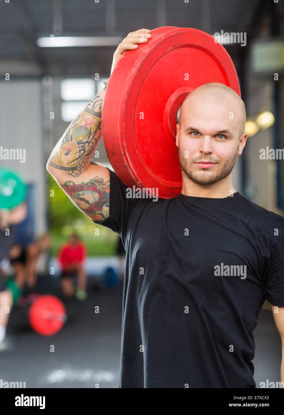 Man Carrying Weightlifting Plate Stock Photo - Alamy