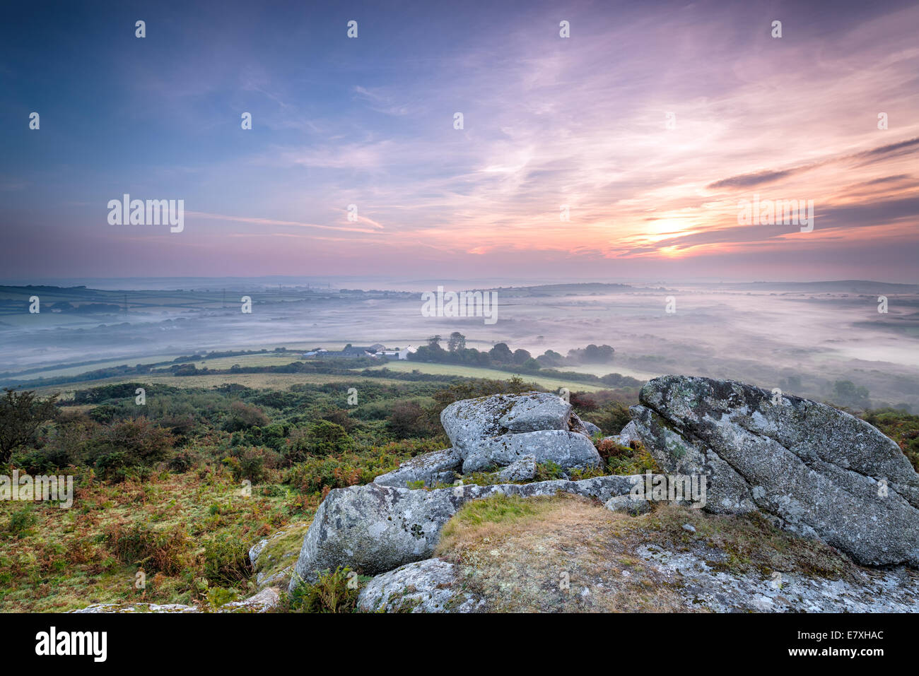 A misty sunrise over the Cornish countryside from Helman Tor, a rugged ...