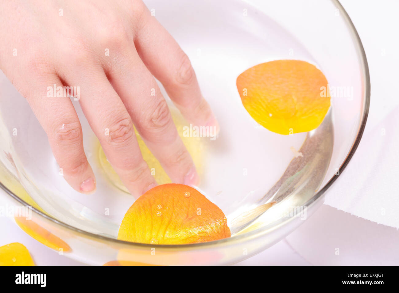 Close up of female hand soaking in glass bowl of water. Manicure and ...