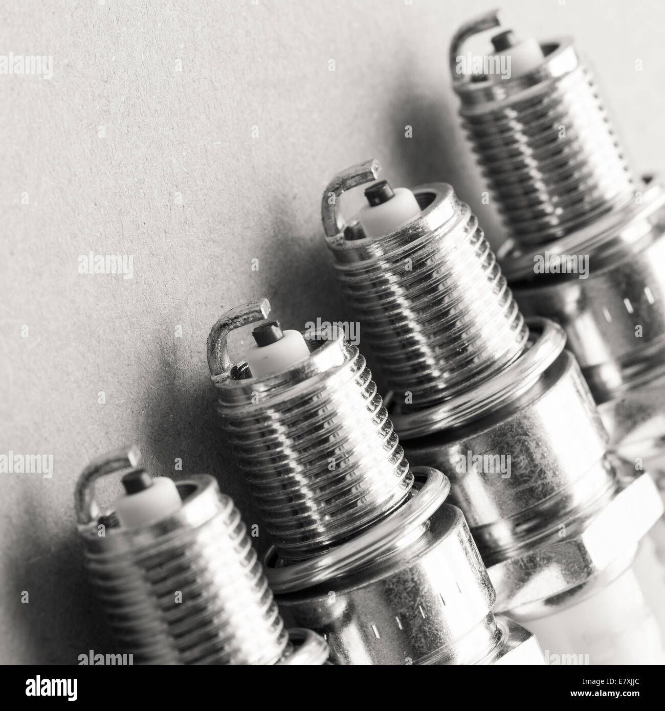 Auto service. Set of new car spark plugs as spare part of auto transportation on gray Stock ...