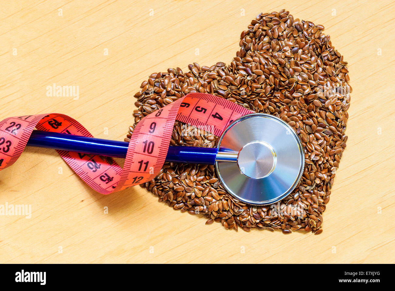 Diet healthcare weight reduction concept. Flax seeds linseed heart shaped stethoscope and ...