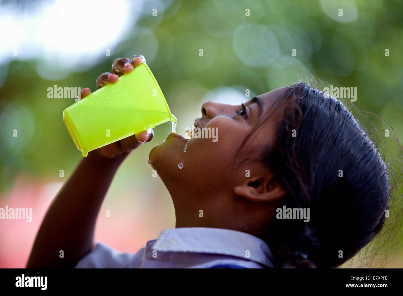 Indian school girl drinking water from a plastic glass Stock Photo - Alamy