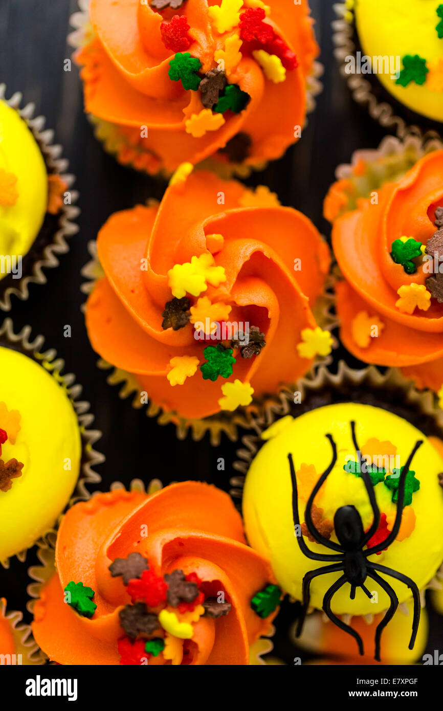 Assorted cupcakes with yellow and orange icing decorated for Autumn ...