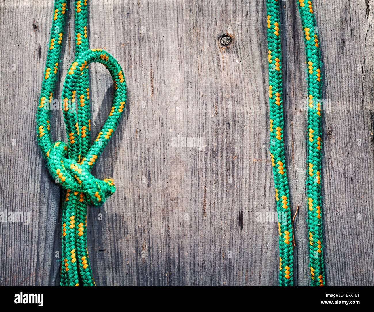 Knotted rope on wooden surface Stock Photo - Alamy
