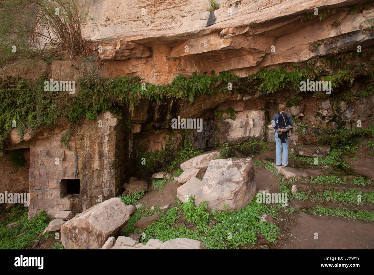 A tourist looking at a Nabatean rock-cut aqueduct in Ain Shalaaleh also ...
