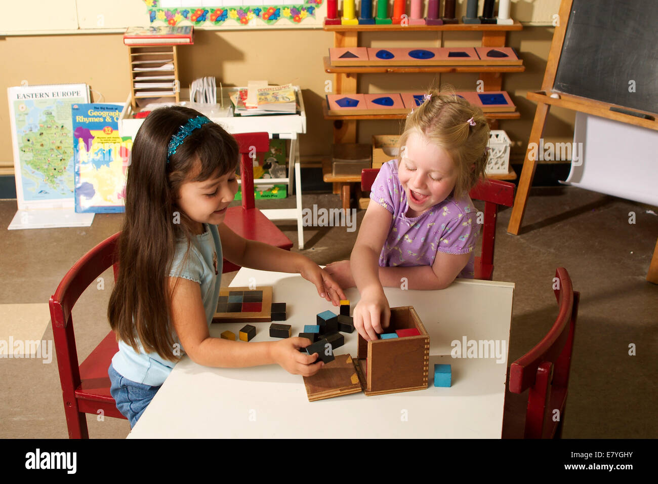 Two interracial diversity racially diverse multicultural girls at table ...
