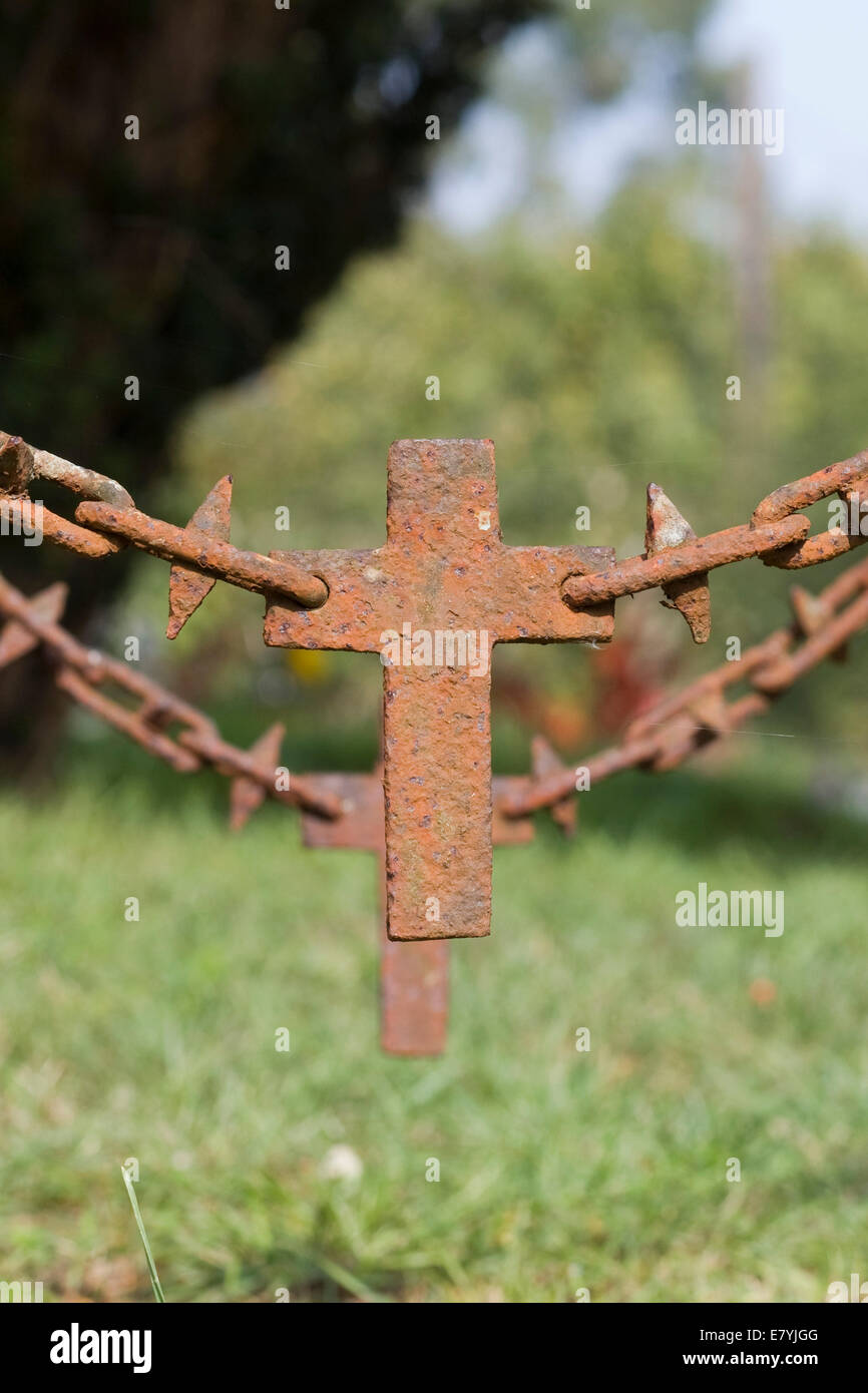Chain link rust colored cross surrounding a grave Stock Photo - Alamy