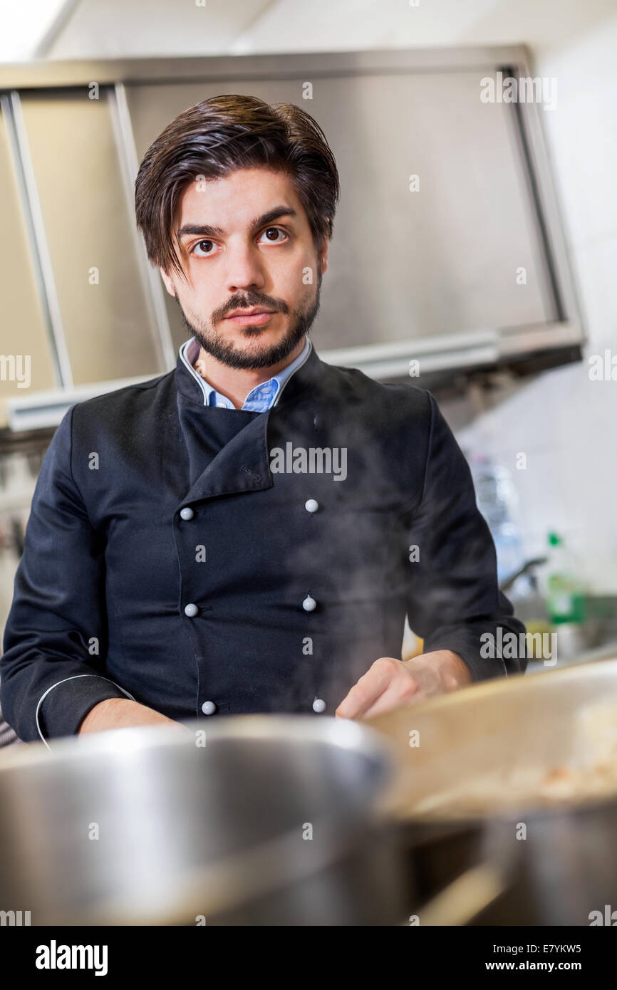 Professional chef in a commercial kitchen cooking a vegetable stir fry ...