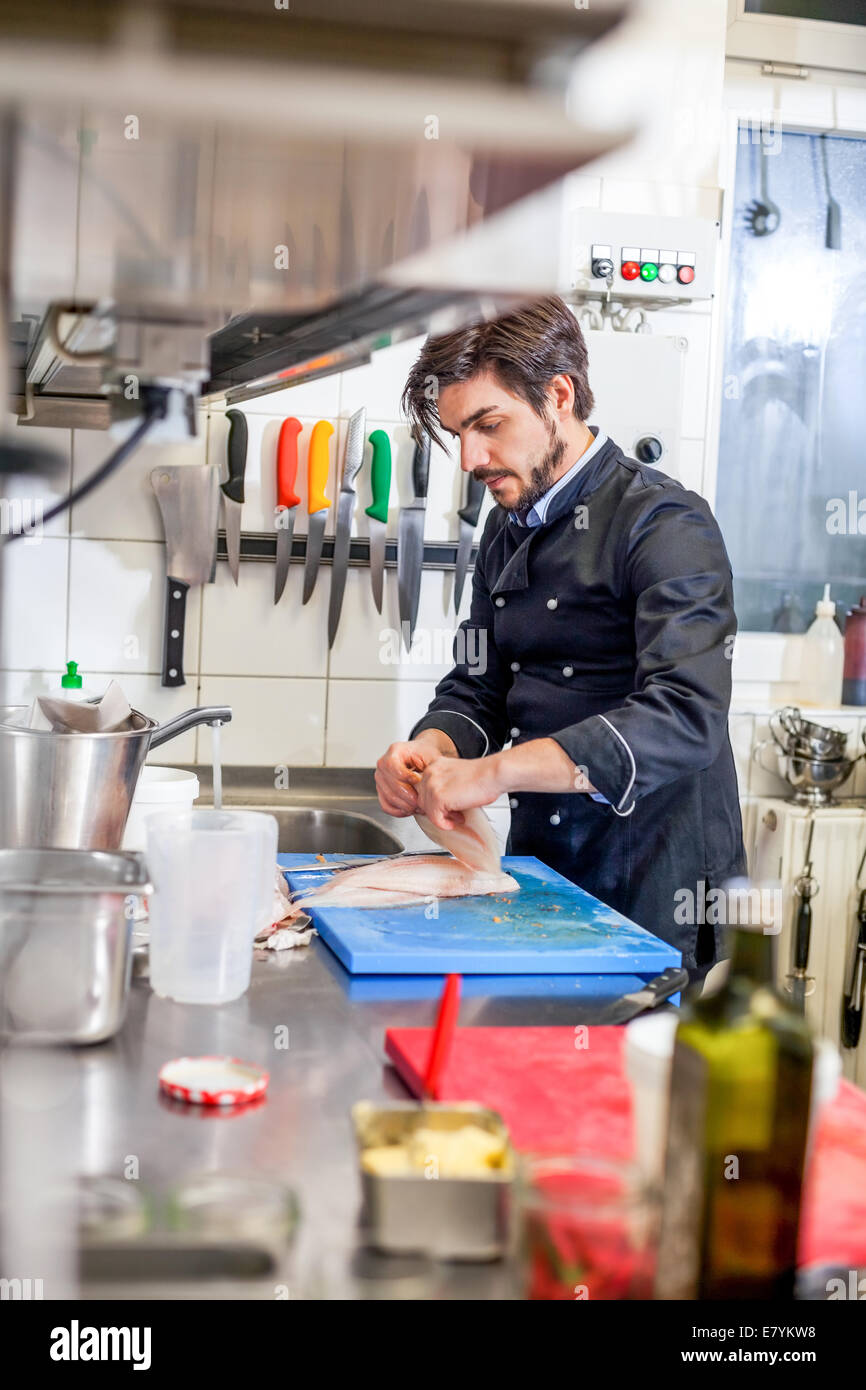 Professional chef in a commercial kitchen cooking a vegetable stir fry ...