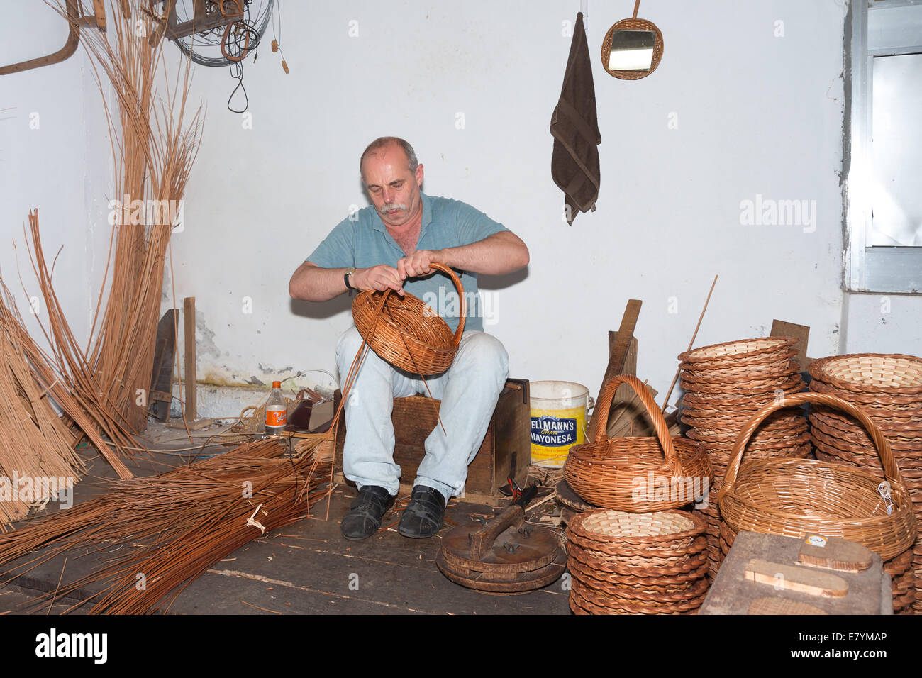 A man is making reed baskets in a braiding factory at Madeira, Portugal ...