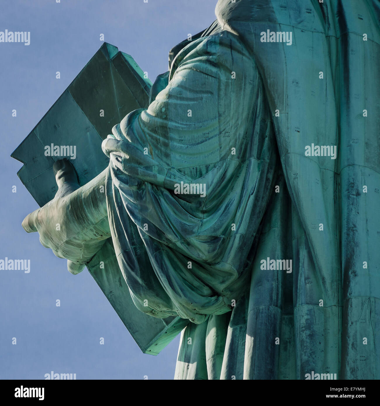 Statue of Liberty closeup of hand holding tablet with blue sky ...