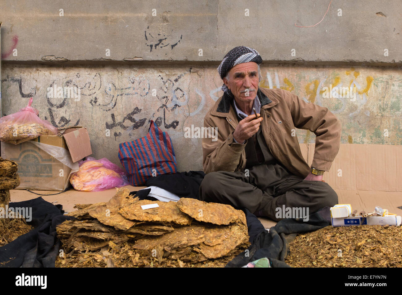 A Kurdish street vendor, wearing traditional clothing, selling tobacco ...