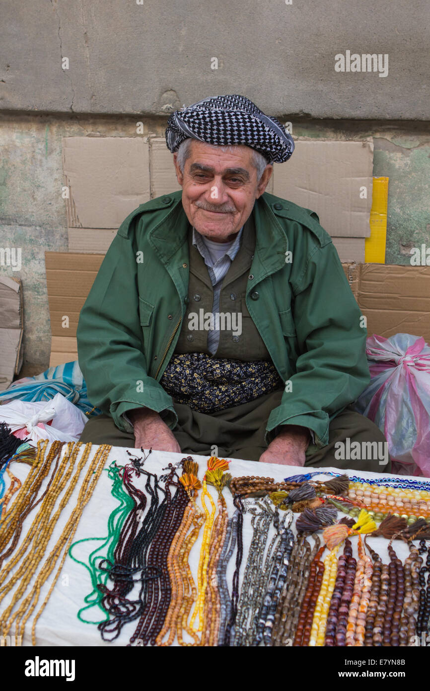 A Kurdish street vendor wearing traditional clothing selling prayer ...