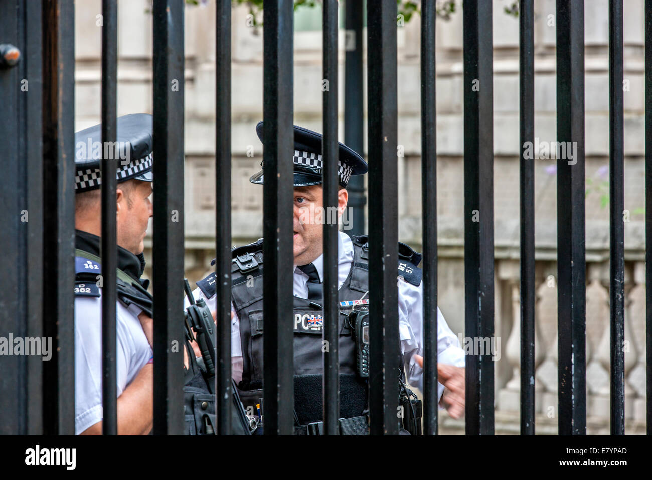 Two London's policemen photographed behind a barrier,(like in jail ...