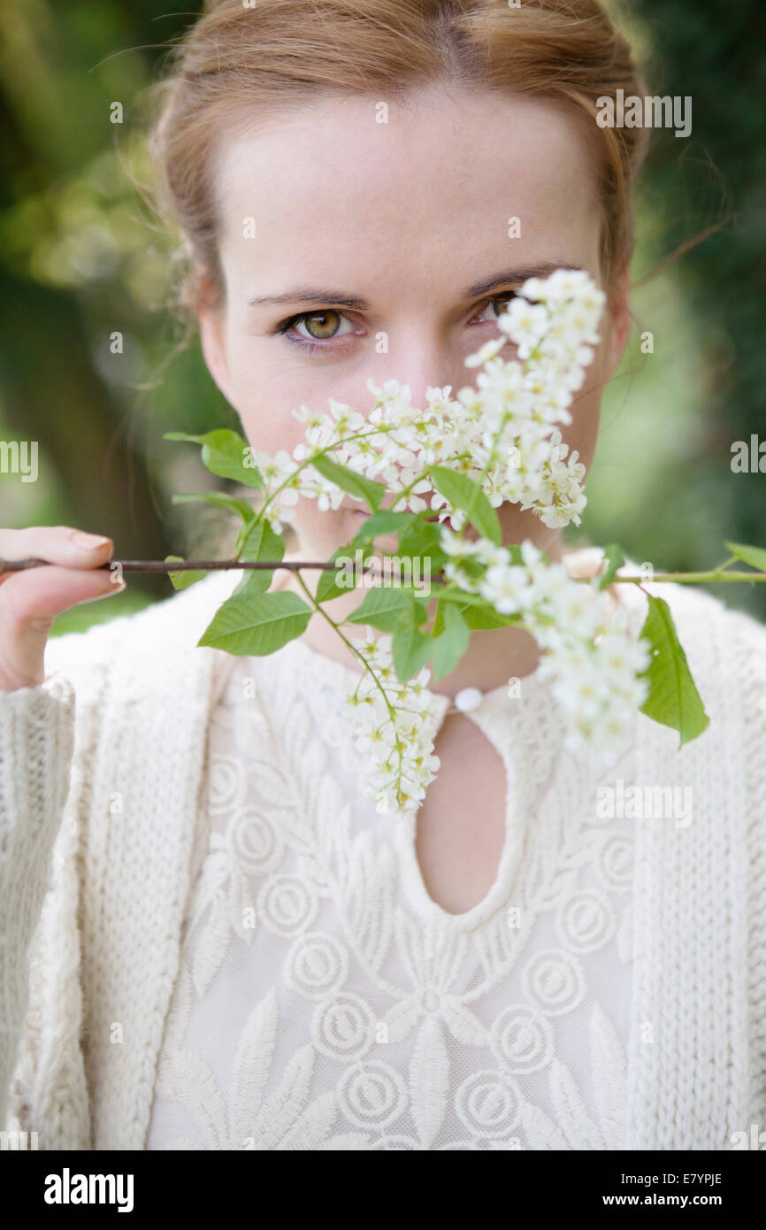 Woman covering her face with flowers Stock Photo - Alamy