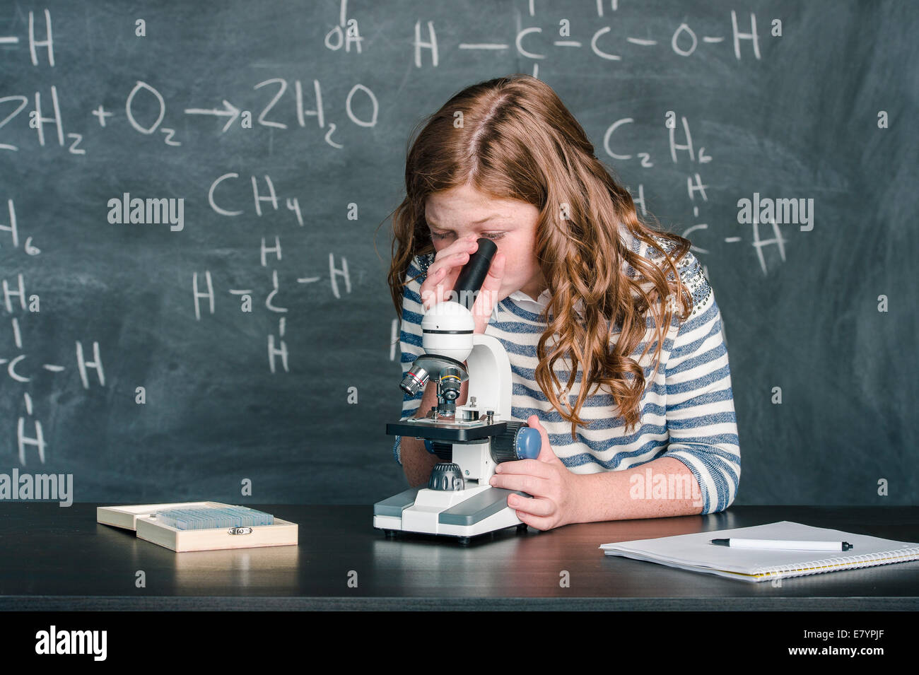 Girl (10-12) looking through microscope Stock Photo - Alamy