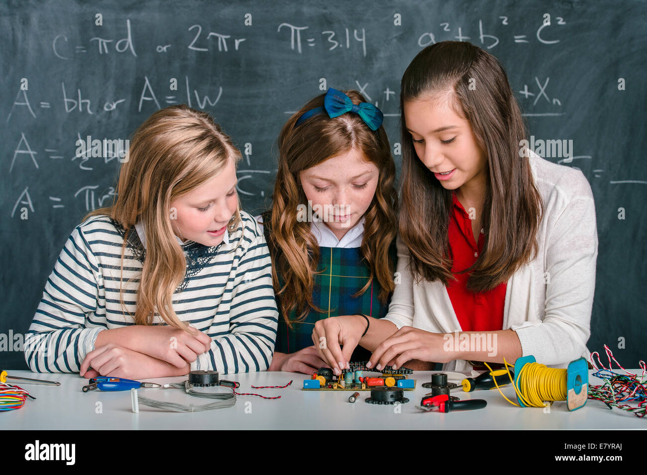 Three girls looking at circuit board Stock Photo - Alamy