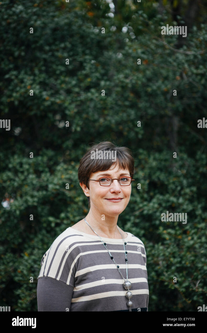 Woman against background of tree foliage Stock Photo - Alamy