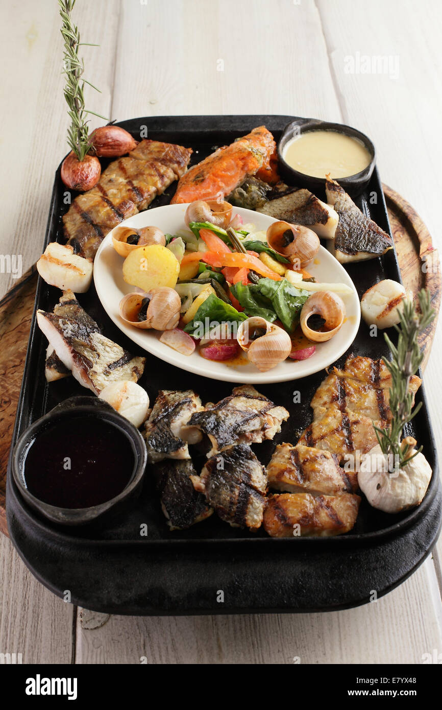 plate of grilled fish on bright background Stock Photo - Alamy