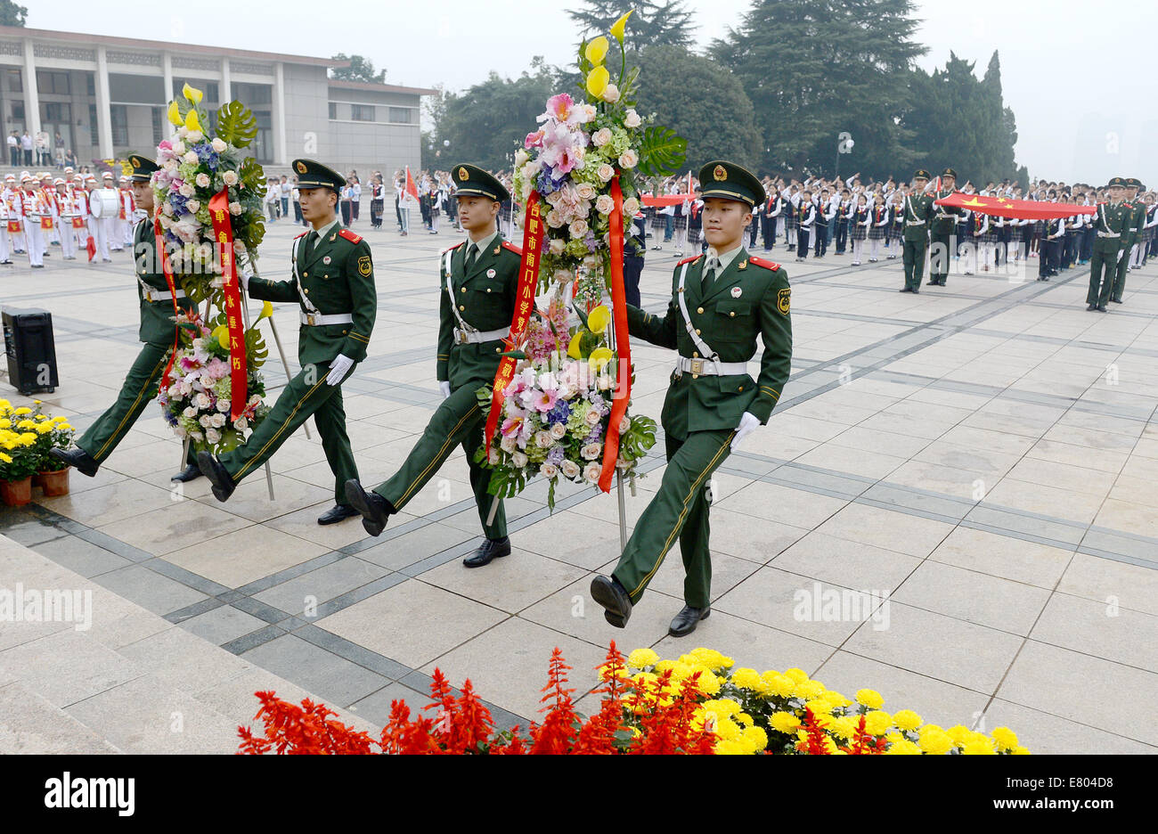 Hefei. 27th Sep, 2014. Armed policemen present flower baskets to a ...