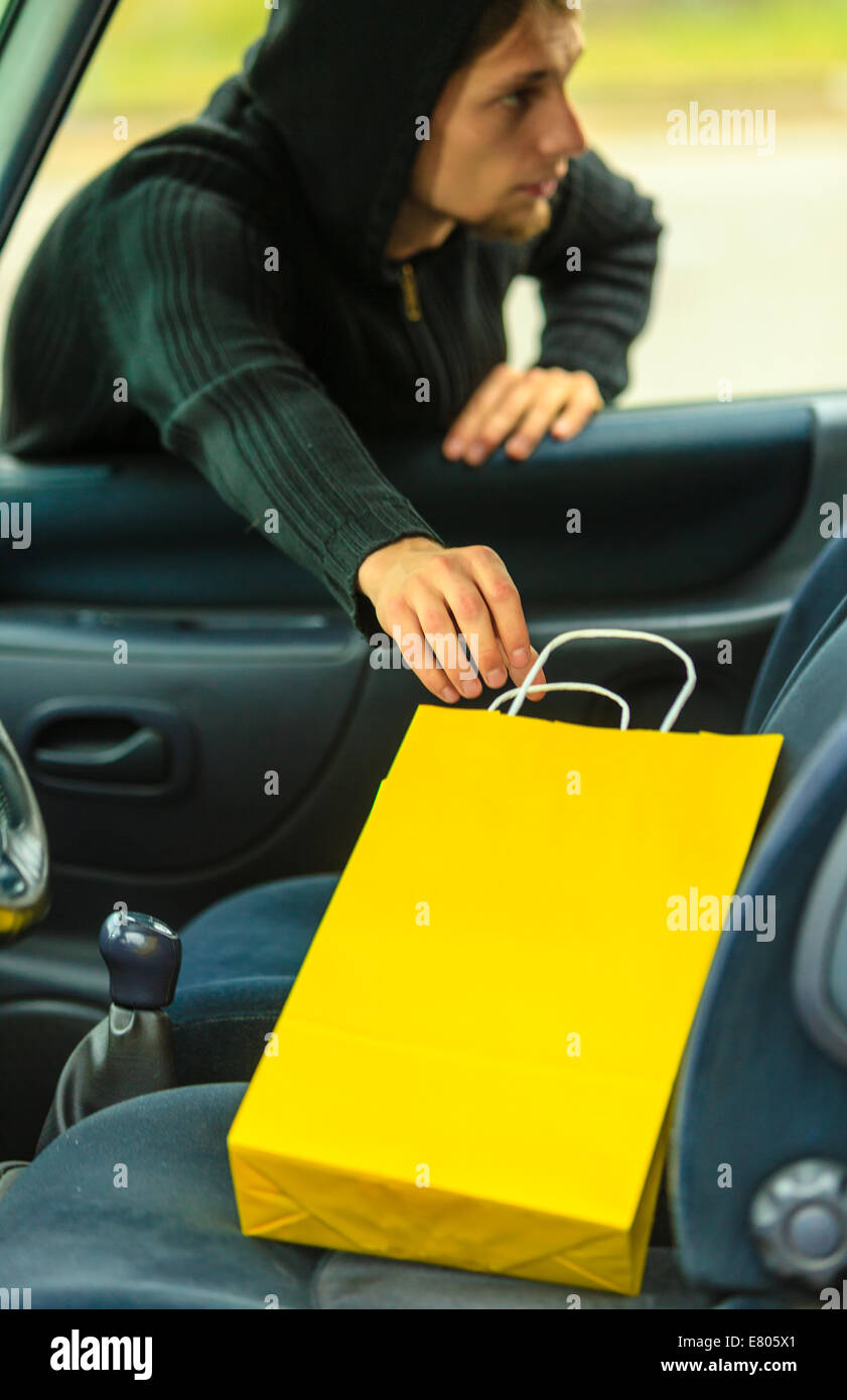 transportation, crime and ownership concept - thief stealing bag from ...