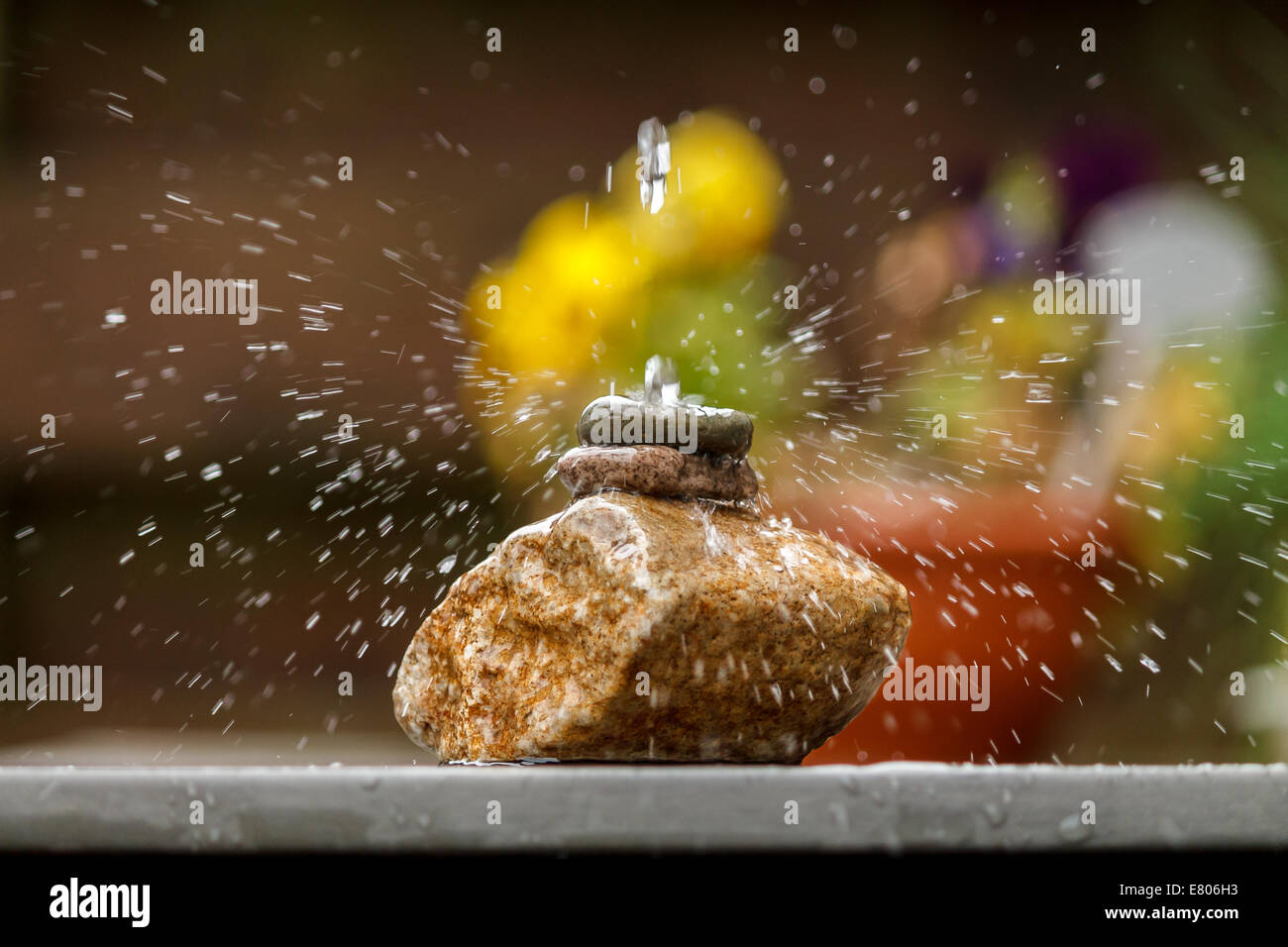 Beautiful splashing water on stones in a garden Stock Photo - Alamy
