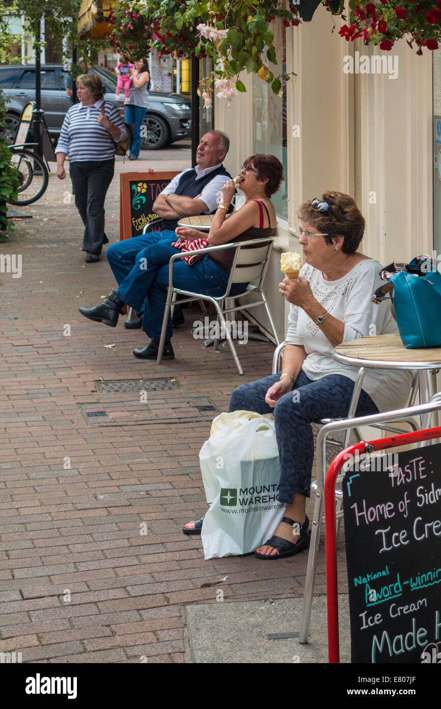 Sidmouth, Devon, England. People sitting outside a cafe on the pavement ...