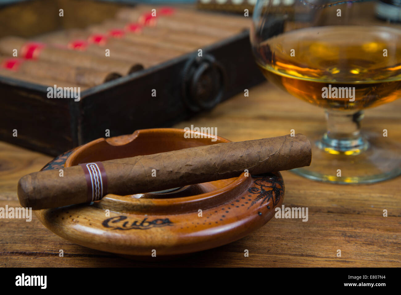 Cuban cigar on wooden table with alcohol Stock Photo - Alamy