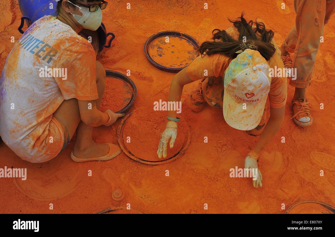 Shanghai, China. 27th Sep, 2014. A volunteer picks up color dust to ...