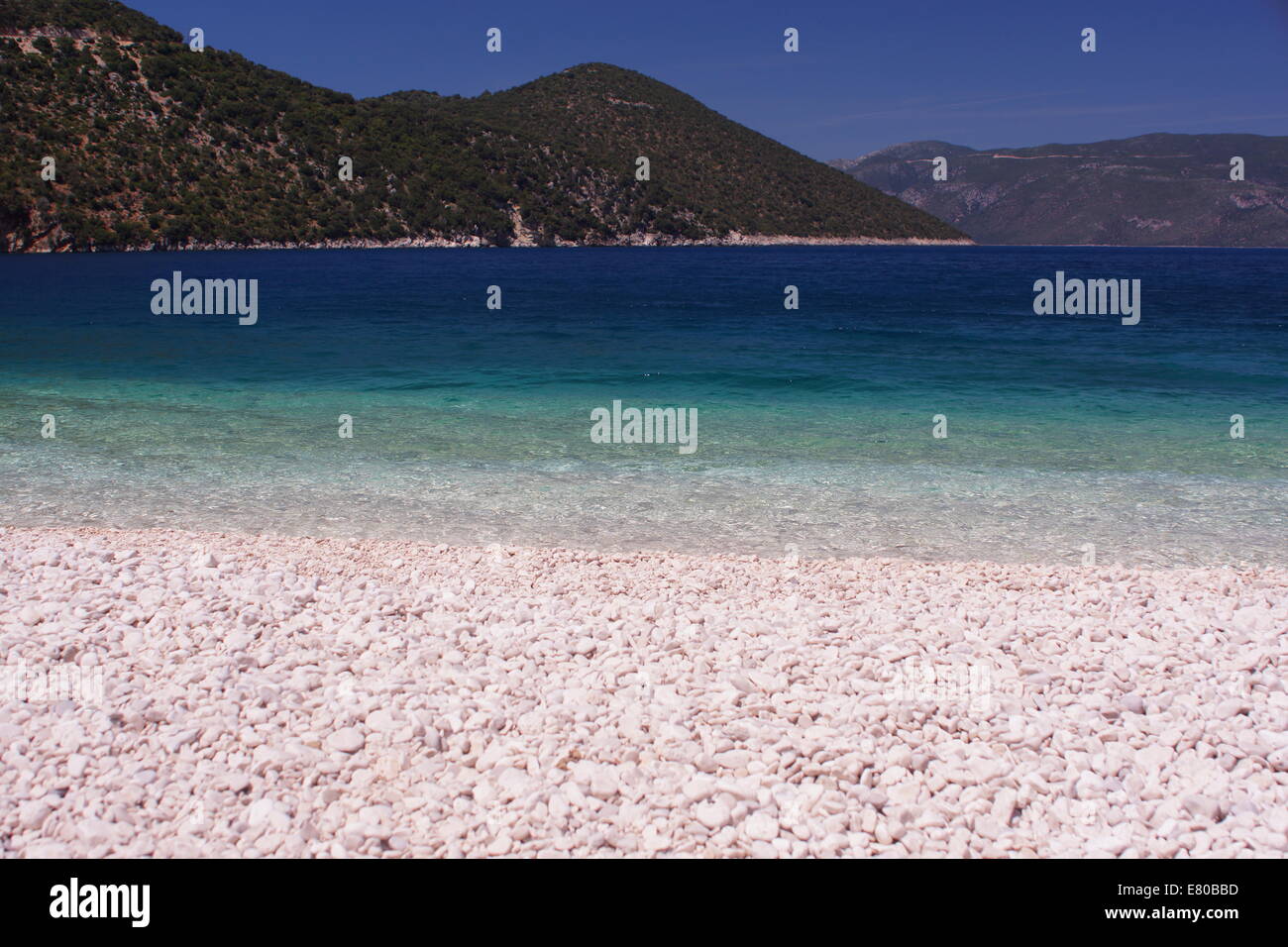 Great contrast of colors, beach scene with pure white pebbles on clear ...