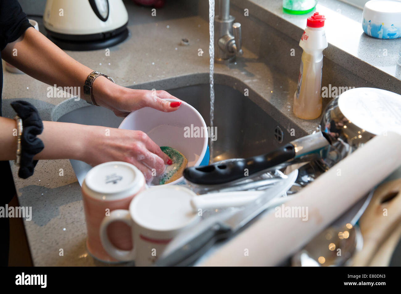 young woman washing up at kitchen sink after baking Stock Photo - Alamy